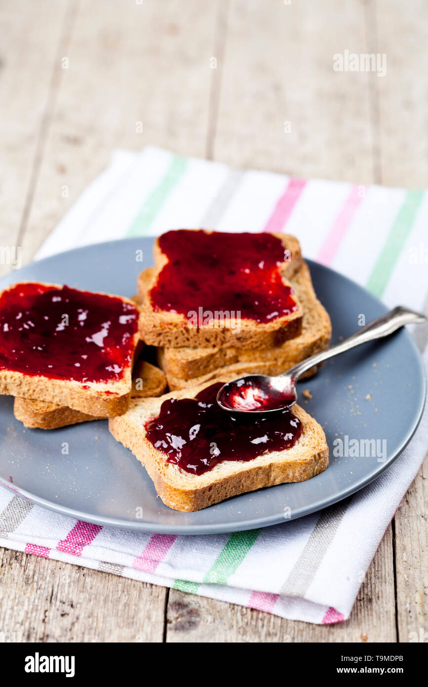 Fresh toasted cereal bread slices with homemade cherry jam and spoon on ...