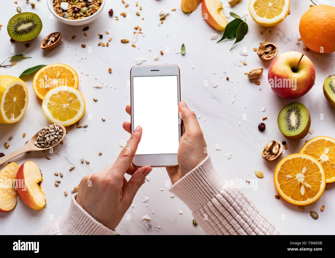 Female hands holding smartphone on healthy food background, woman using ...