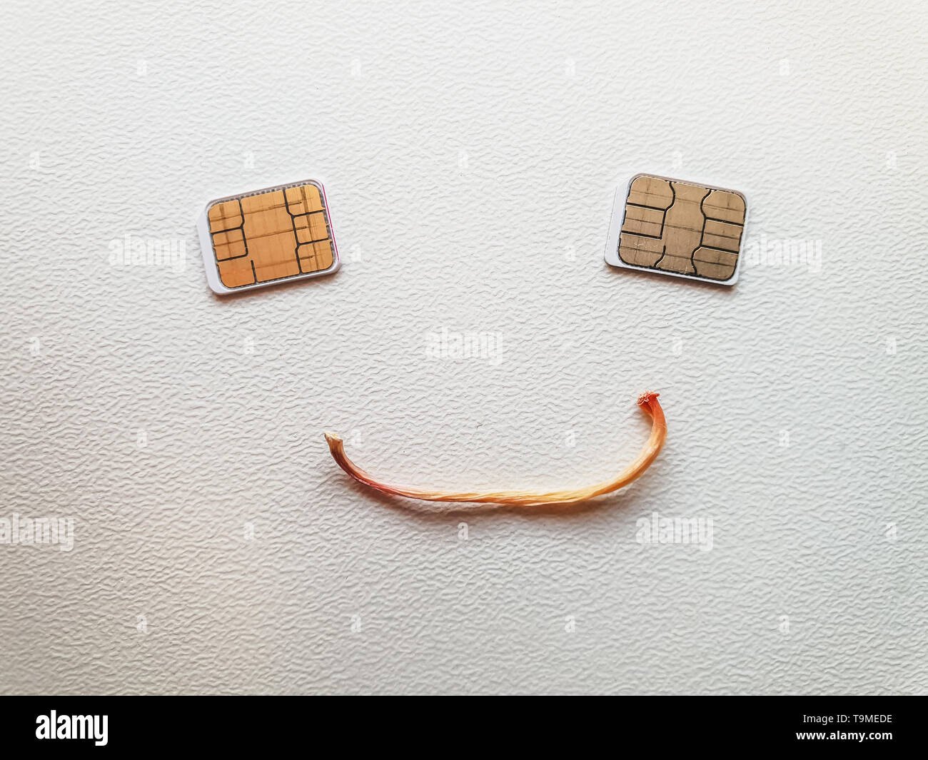 two micro sim cards lying in the shape of a sad face Stock Photo - Alamy