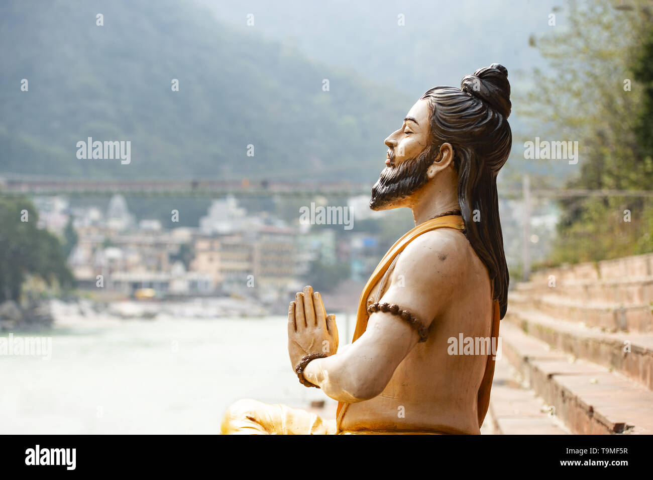 Stunning view of a sitting Hindu statue on the riverbank of the Ganges ...