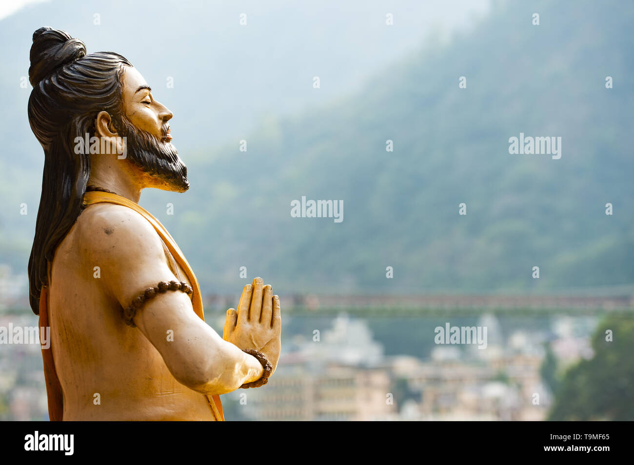 Stunning view of a sitting Hindu statue on the riverbank of the Ganges ...