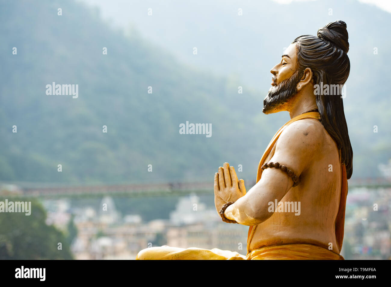 Stunning view of a sitting Hindu statue on the riverbank of the Ganges ...