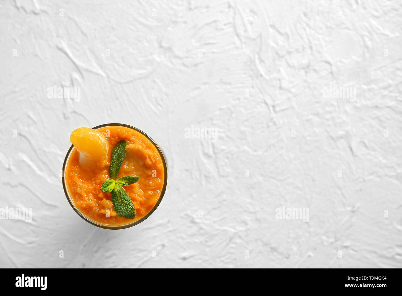 Glass of tasty orange smoothie on white table Stock Photo - Alamy