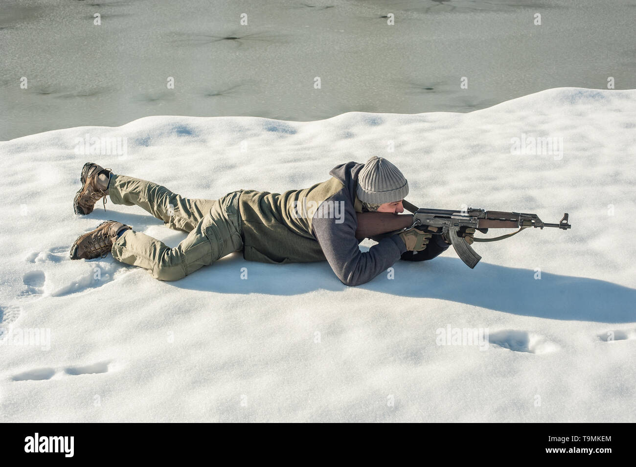 Instructor demonstrate body position of combat rifle shooting at winter ...