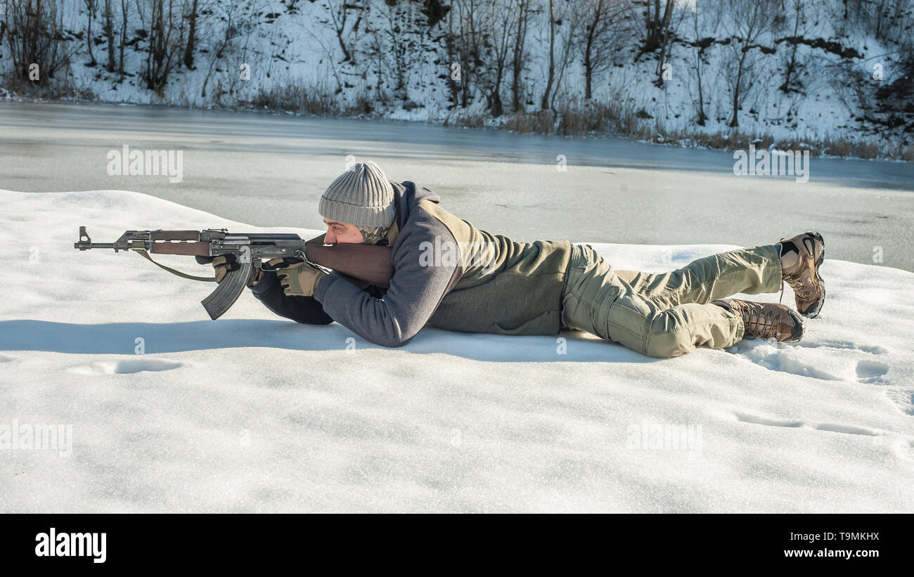 Instructor demonstrate body position of combat rifle shooting at winter ...