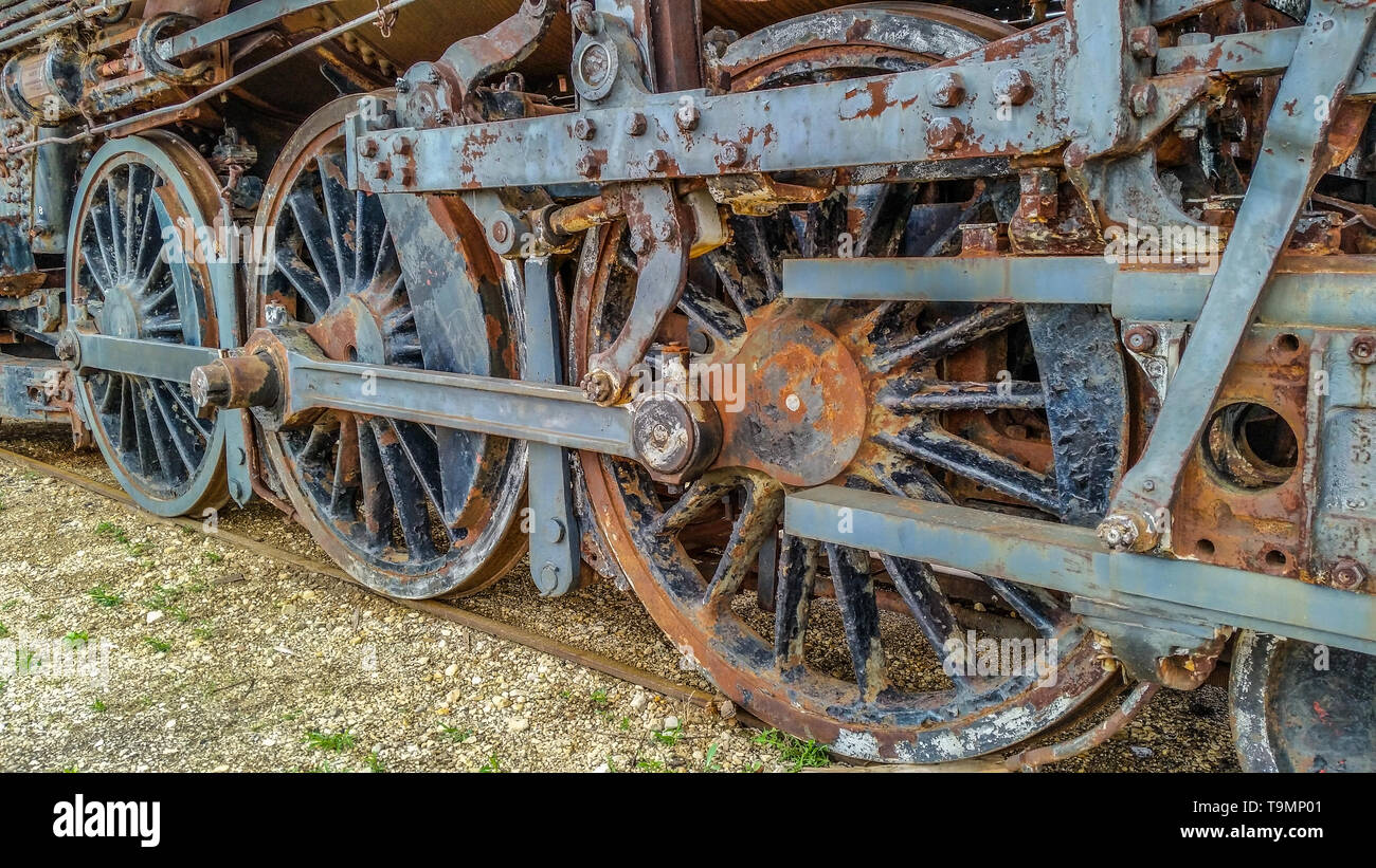 Rusty wheels on a old steam locomotive sitting abandoned in a rail yard ...