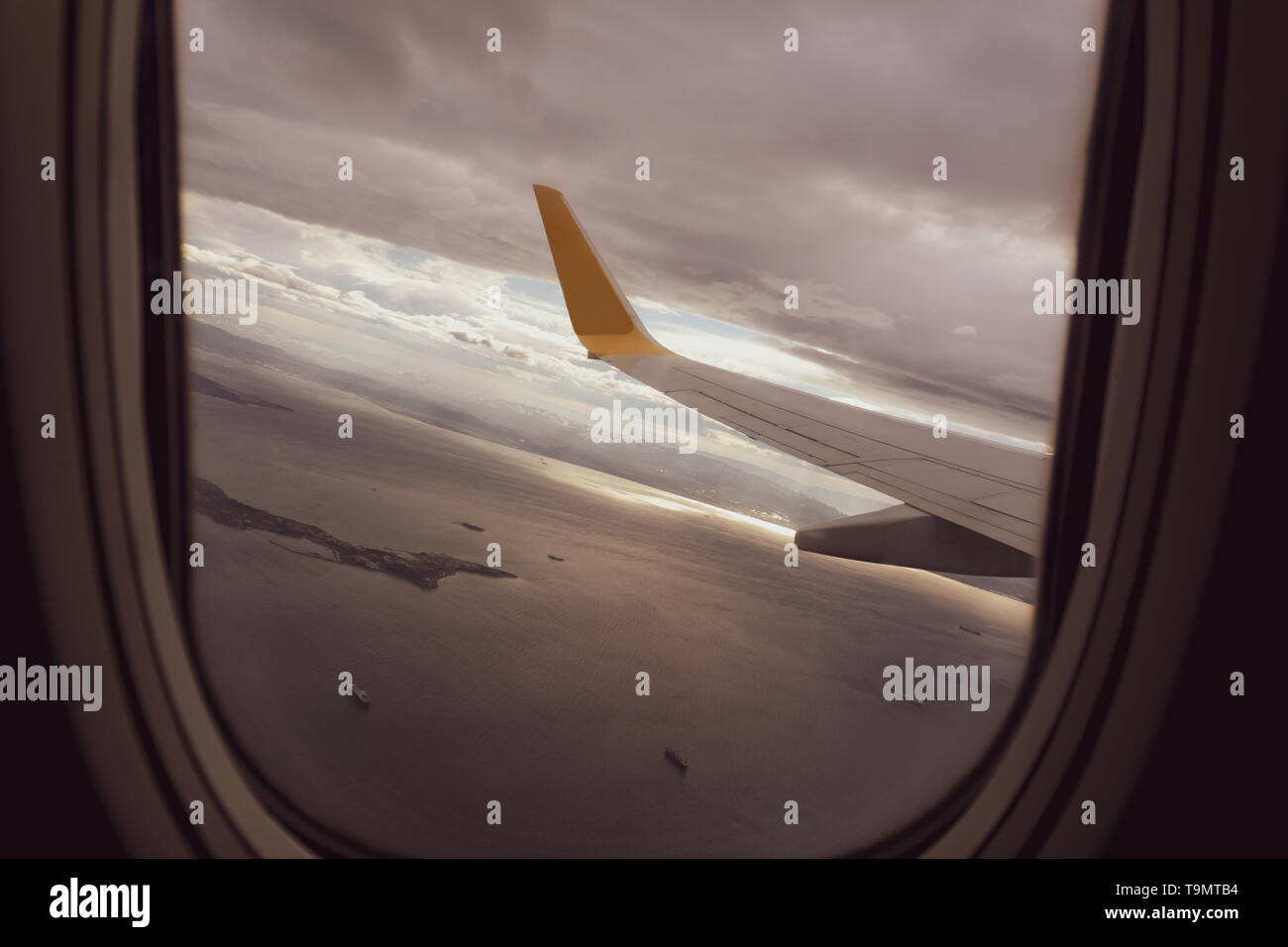 Vintage coloured aerial view of blue sky and cloud seen through window ...