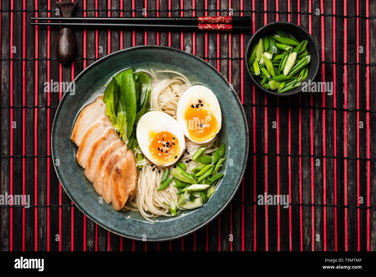 Ramen noodle soup with chicken and egg on bamboo mat. Table top view ...