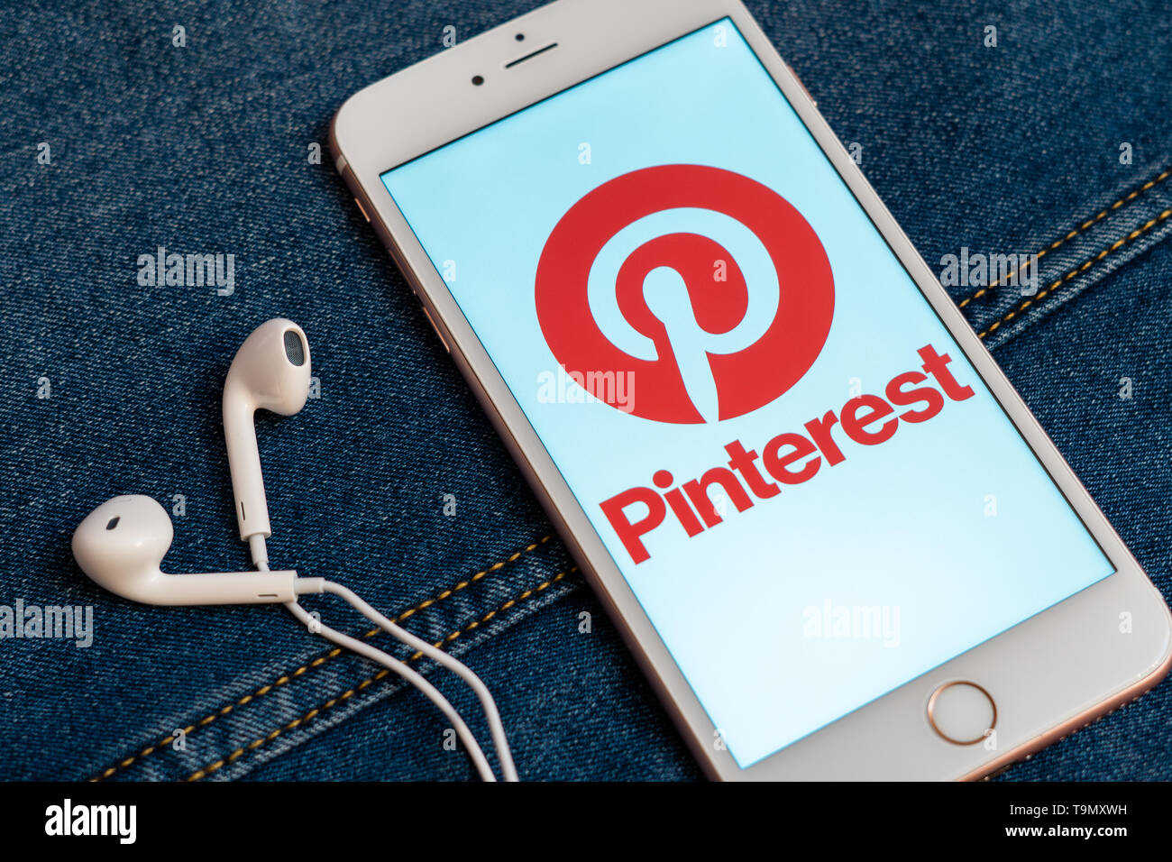 White iPhone with logo of social media Pinterest on the screen. Social ...