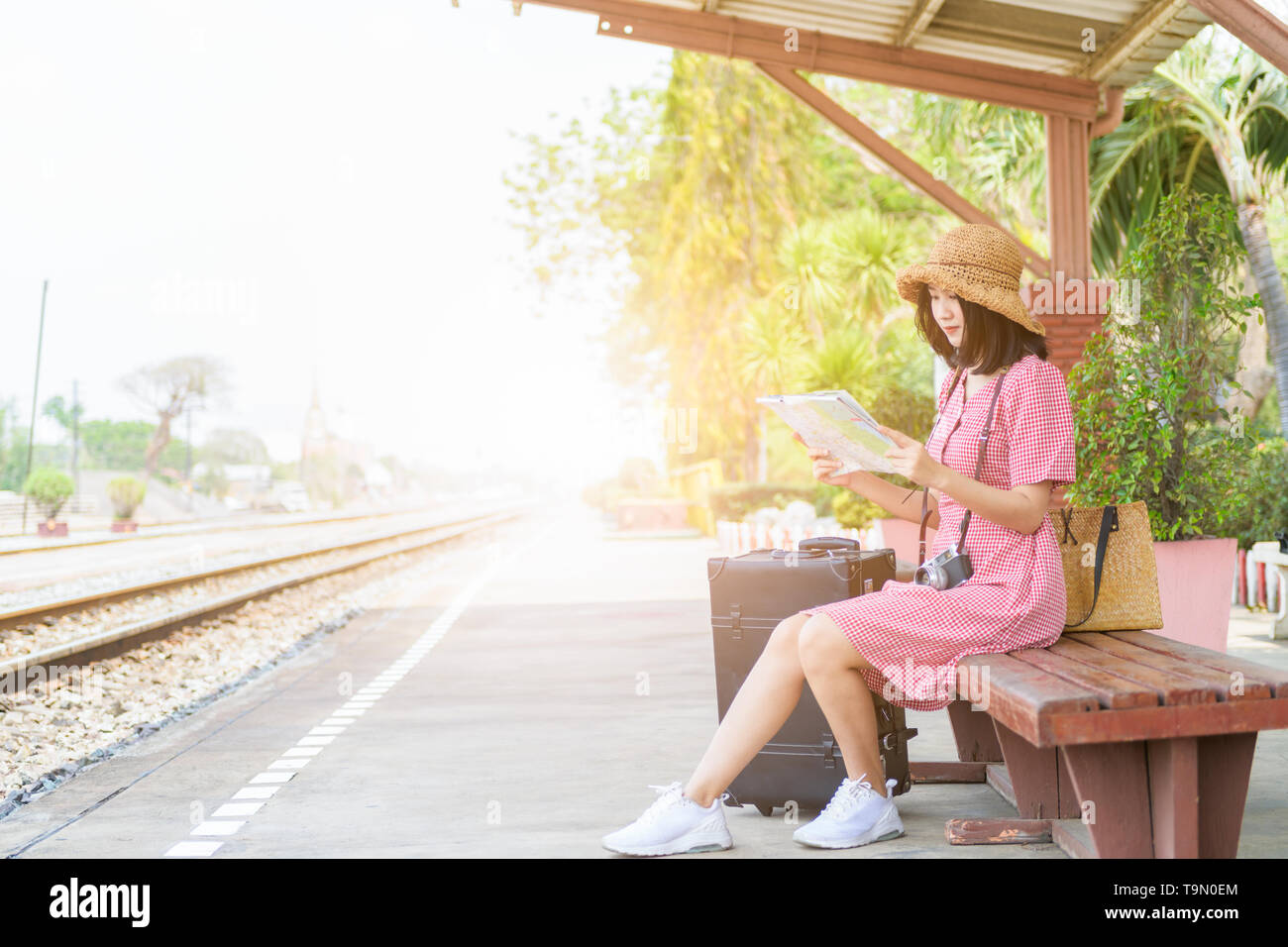 Hipster woman watching the map and waiting for the train to travel at ...