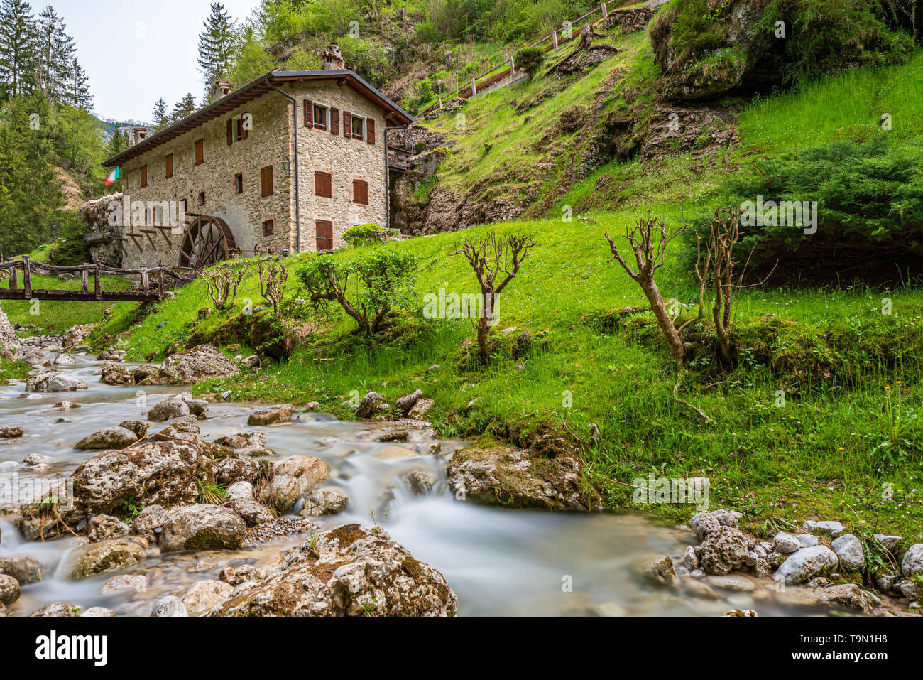 Ancient mill on the river with small wooden bridge Stock Photo - Alamy