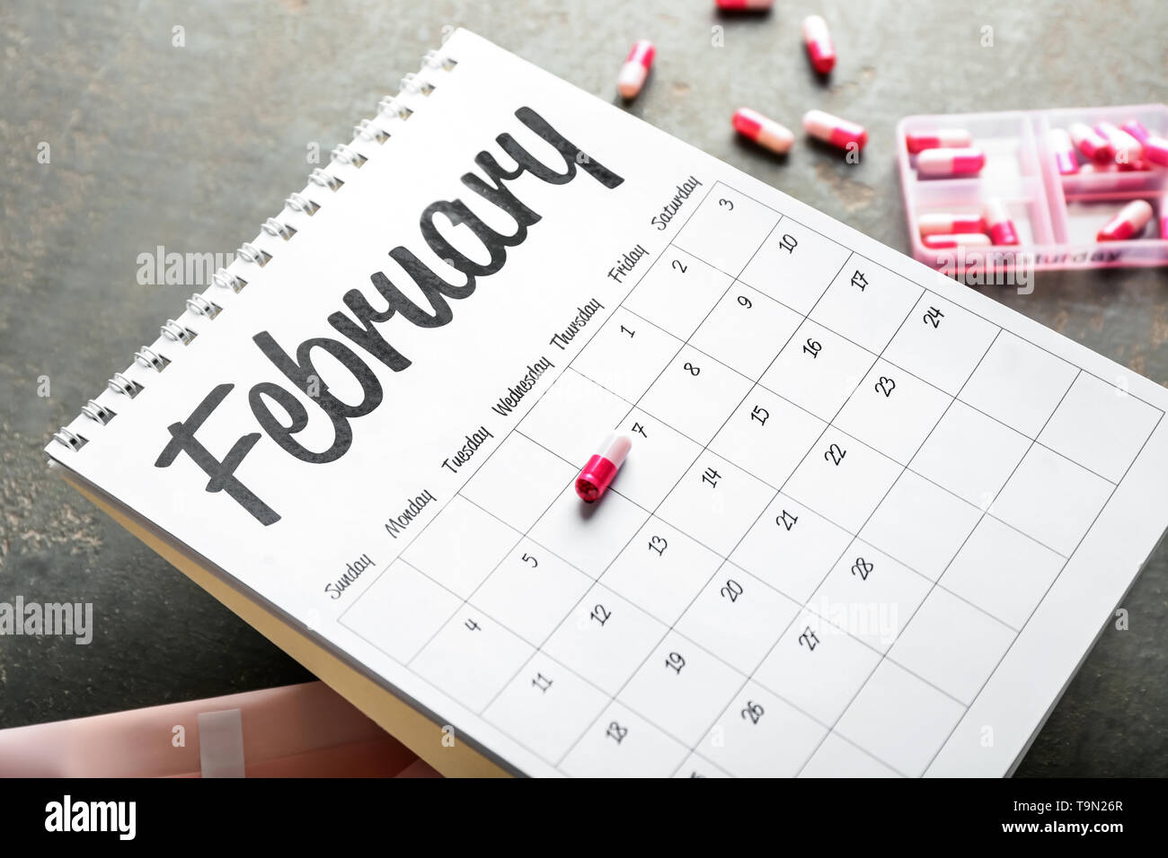 Menstrual calendar on grey table Stock Photo - Alamy