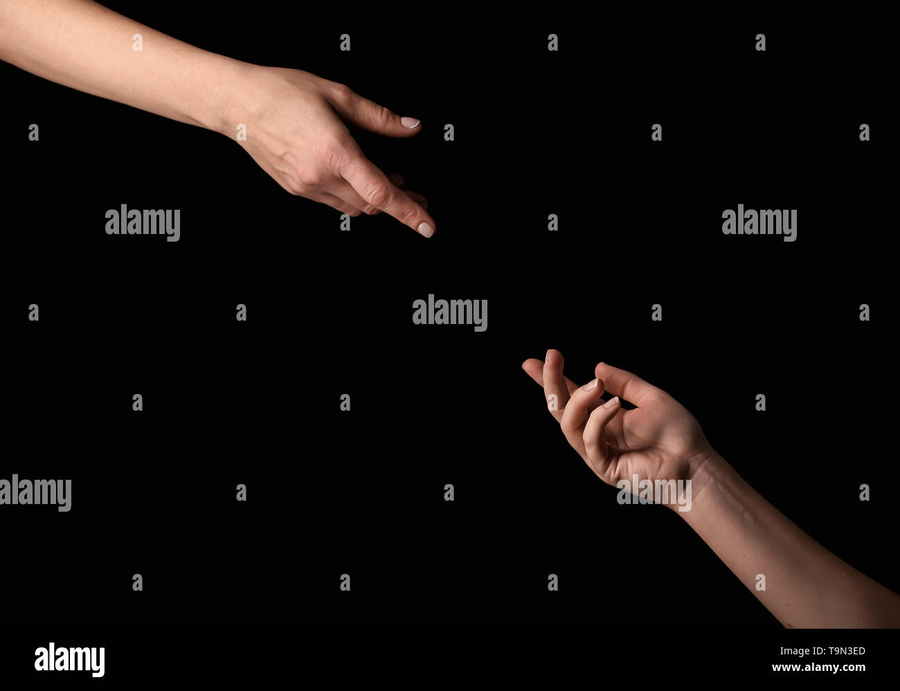 Female hands reaching out to each other on dark background Stock Photo ...