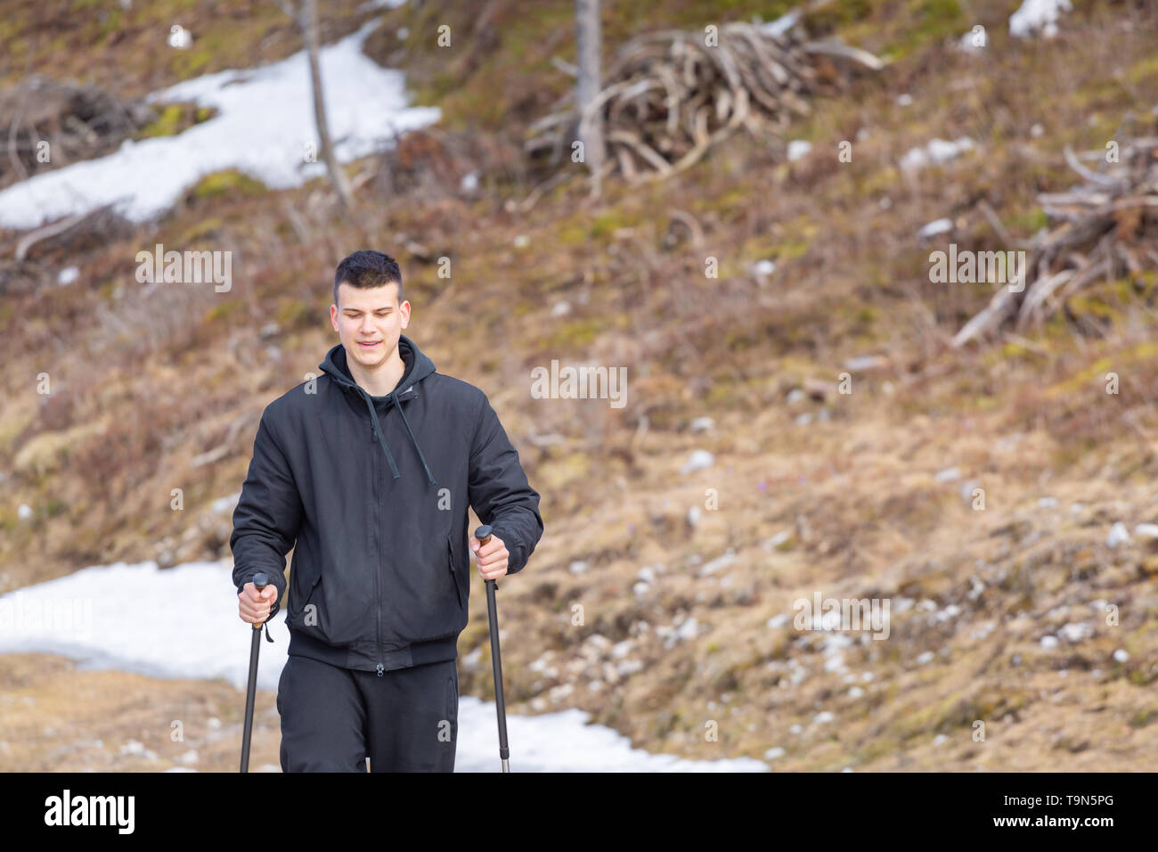 Casual and active healthy man hiking in Alpine mountains with trekking ...