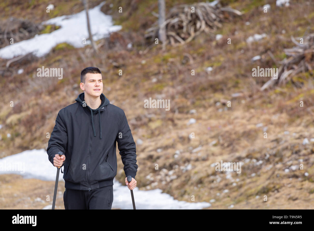 Casual and active healthy man hiking in Alpine mountains with trekking ...