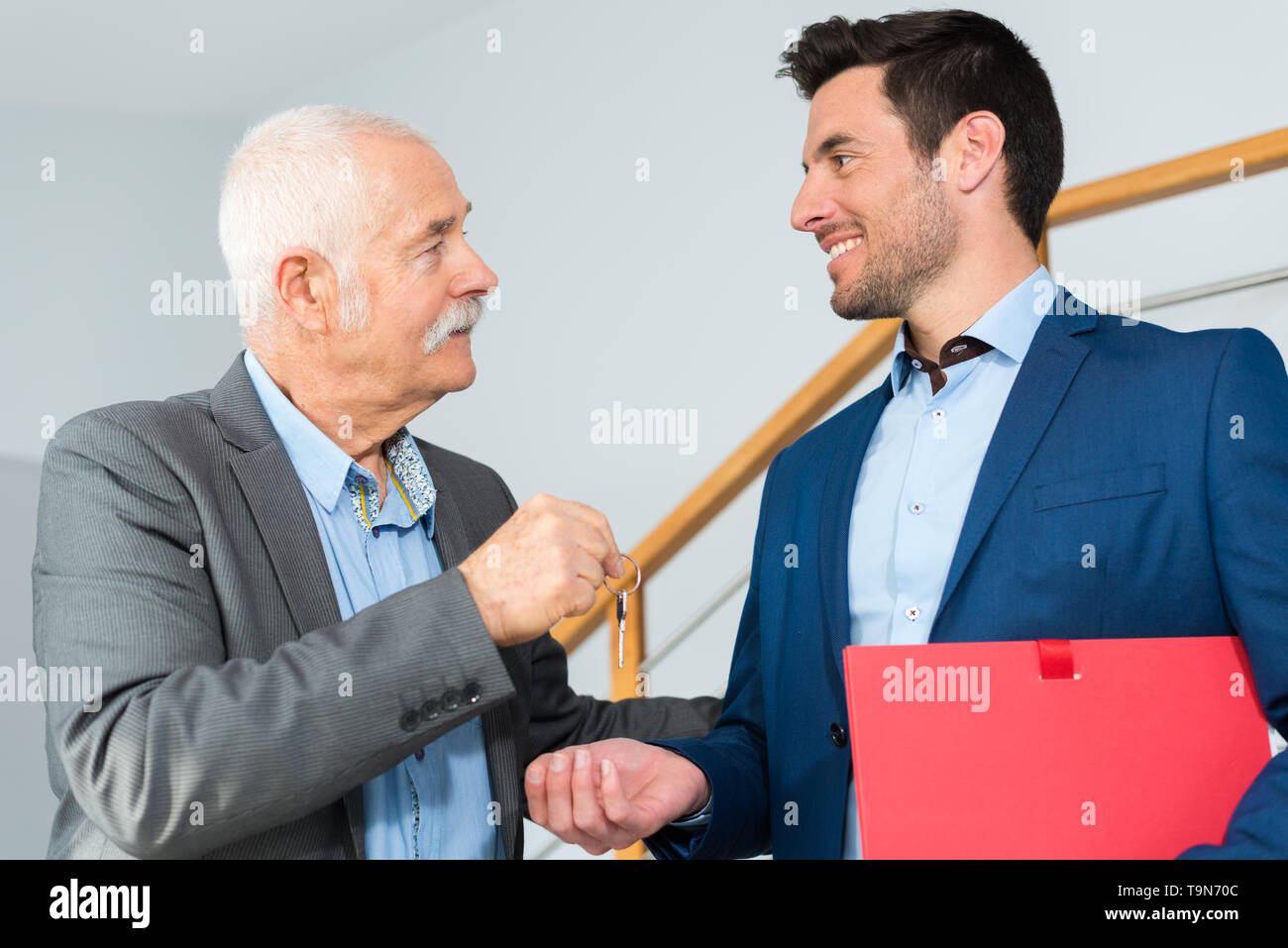 senior businessman passing keys to younger man Stock Photo - Alamy