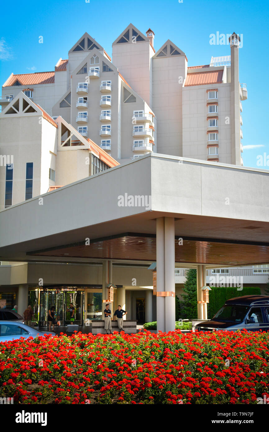 Valet entrance to building has Beautiful landscaping with red geraniums ...