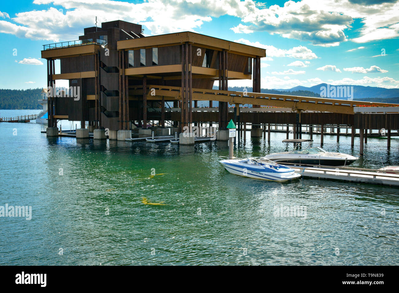 A modern wooden marina building on stilts alongside the floating ...
