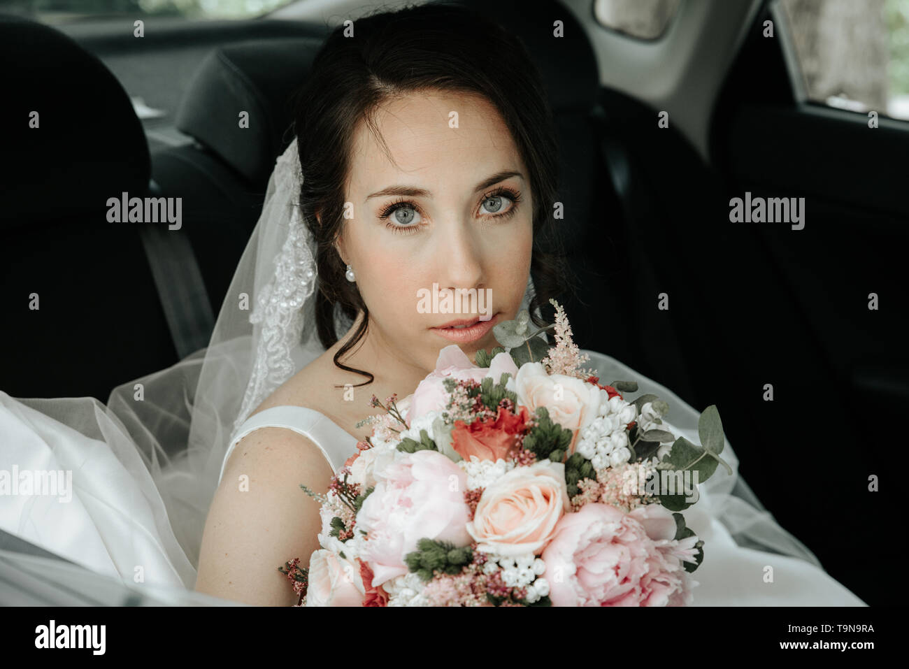 close-up portrait of a pretty bride in a car window with nice wedding ...