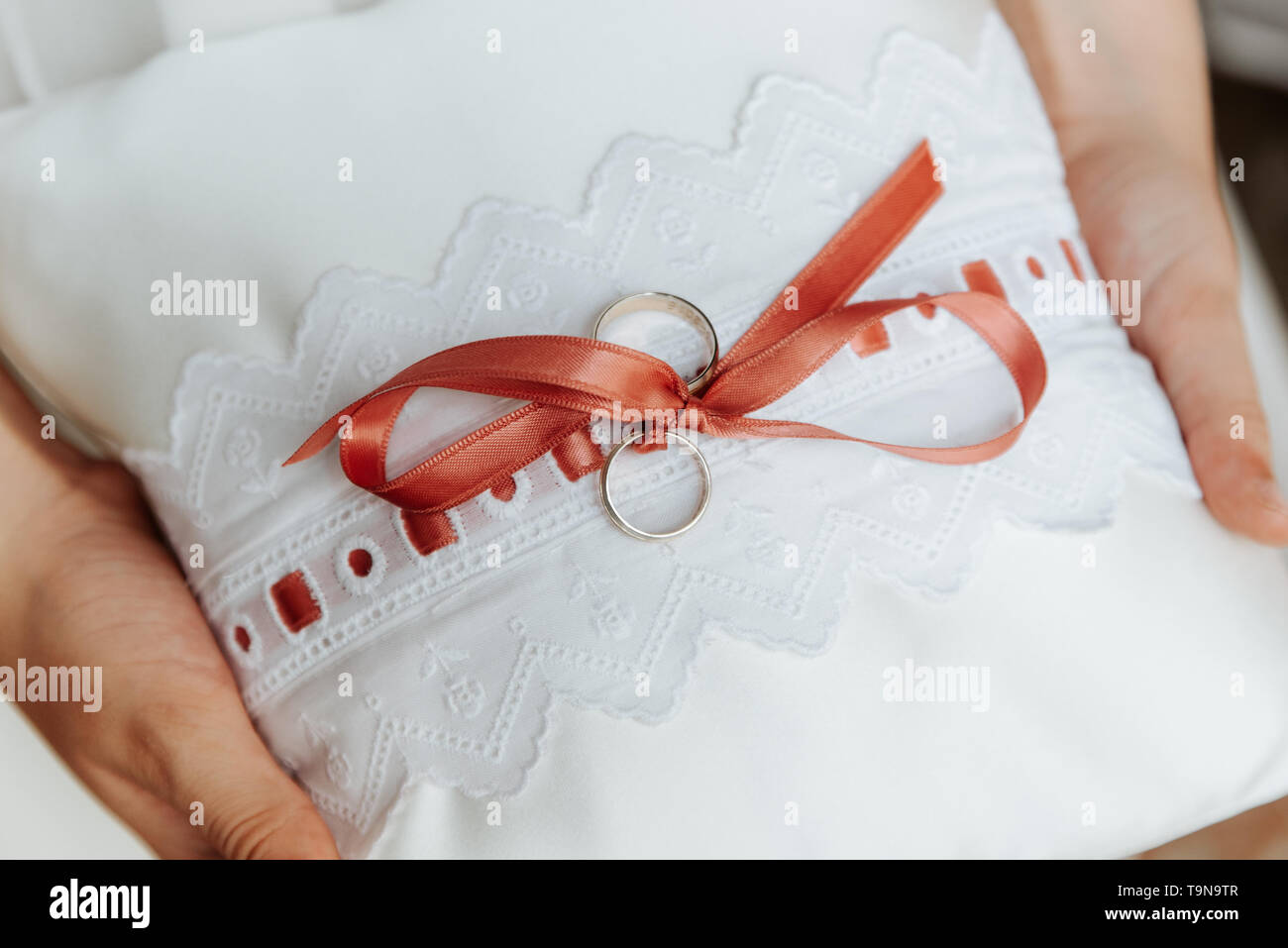 Gold wedding rings red ribbon hi-res stock photography and images - Alamy