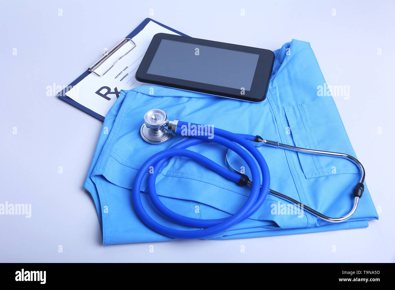 Medical stethoscope lying on a blue doctor's form and notepad close-up ...