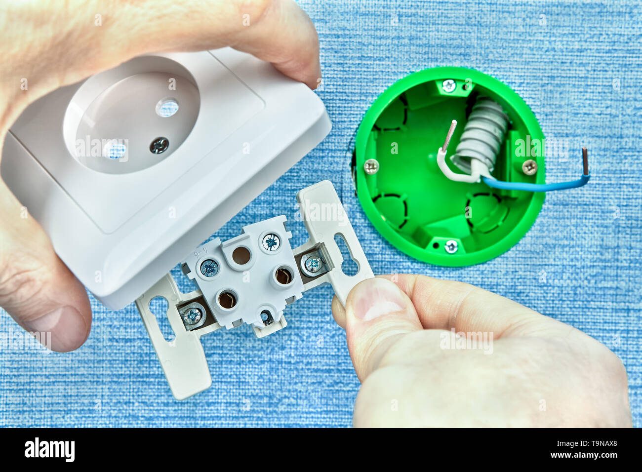 Electrician is installing new wall plug socket, electrical maintenance ...