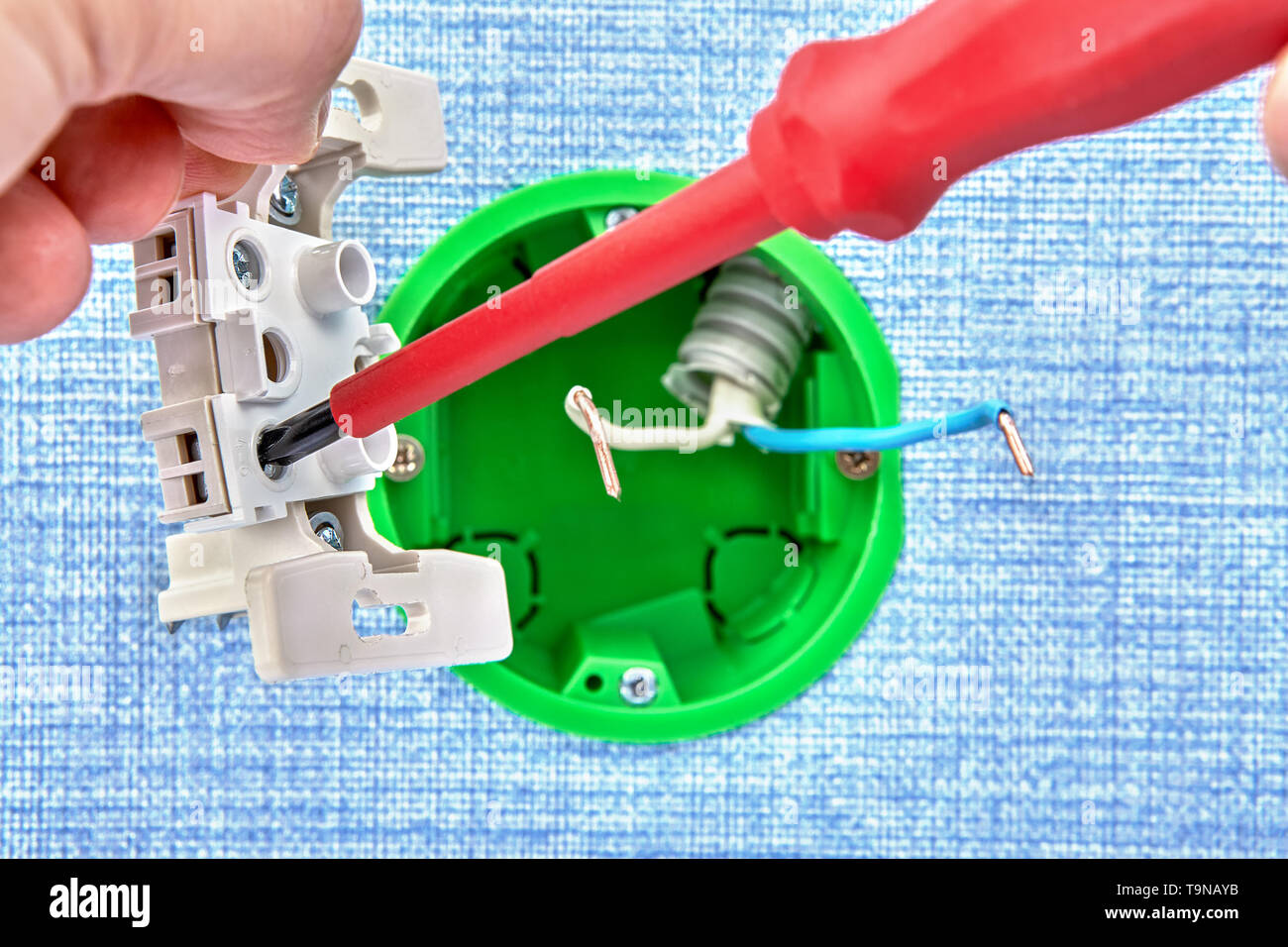 Repairman is twisting screw in new european standard round electrical ...