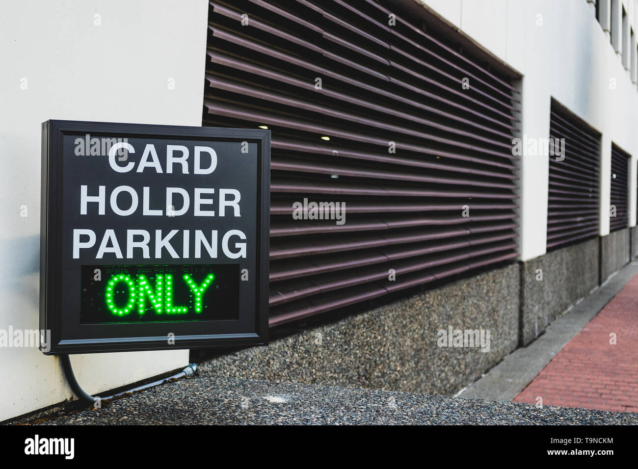 Card holder parking only sign in front of a garage door Stock Photo - Alamy