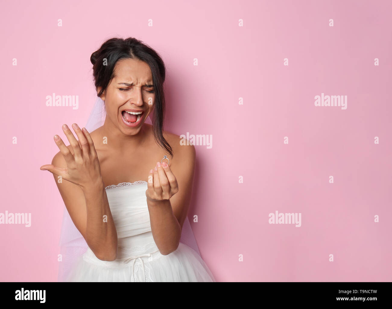 Screaming young bride with wedding ring on color background Stock Photo ...