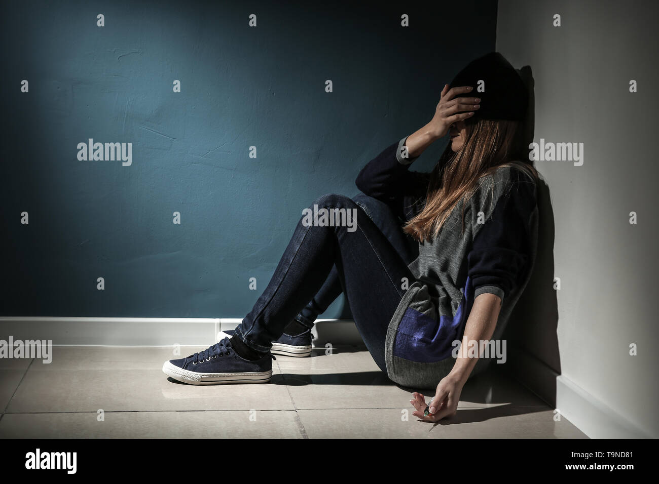 Female junkie with syringe sitting on floor. Concept of addiction Stock ...
