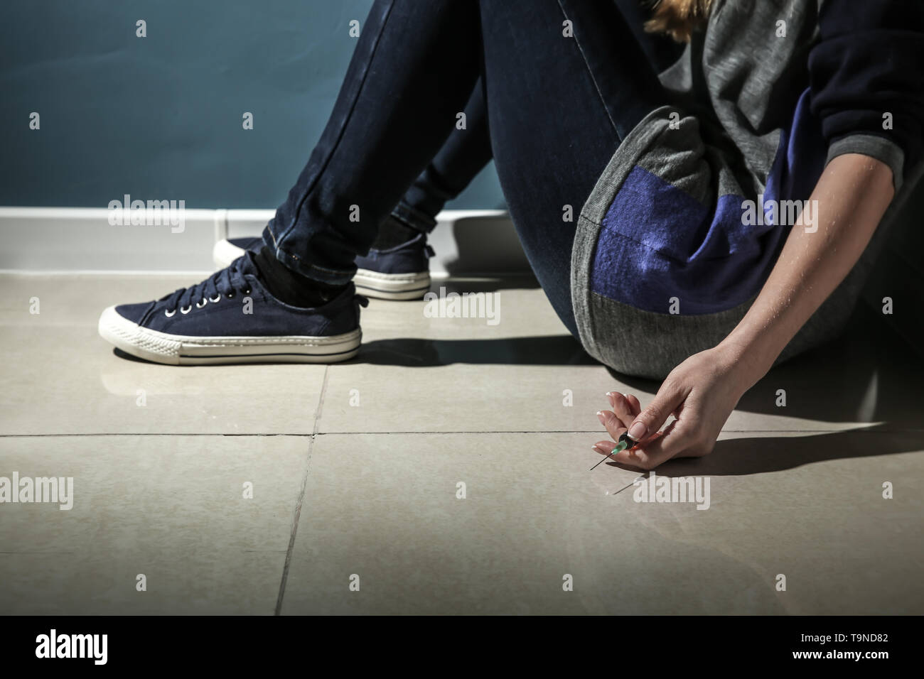 Female junkie with syringe sitting on floor. Concept of addiction Stock ...