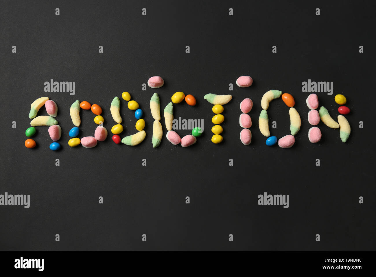 Word ADDICTION made with candies on dark background Stock Photo - Alamy