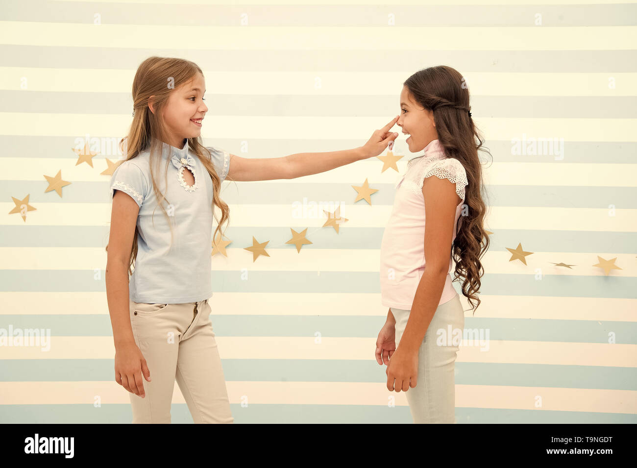 Girls smiling happy faces play or interact stand striped background ...
