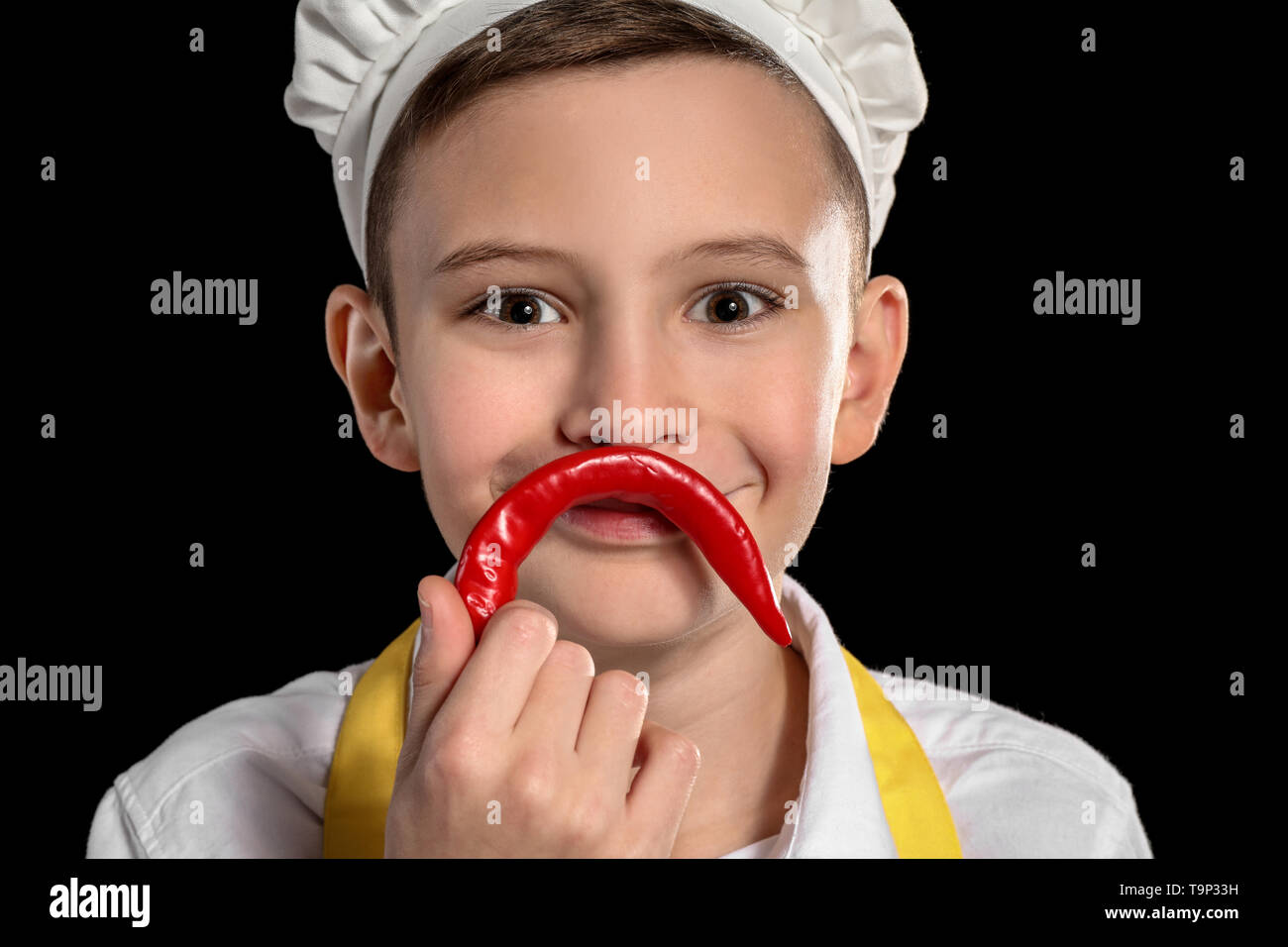 Funny little chef with chili pepper on dark background Stock Photo - Alamy