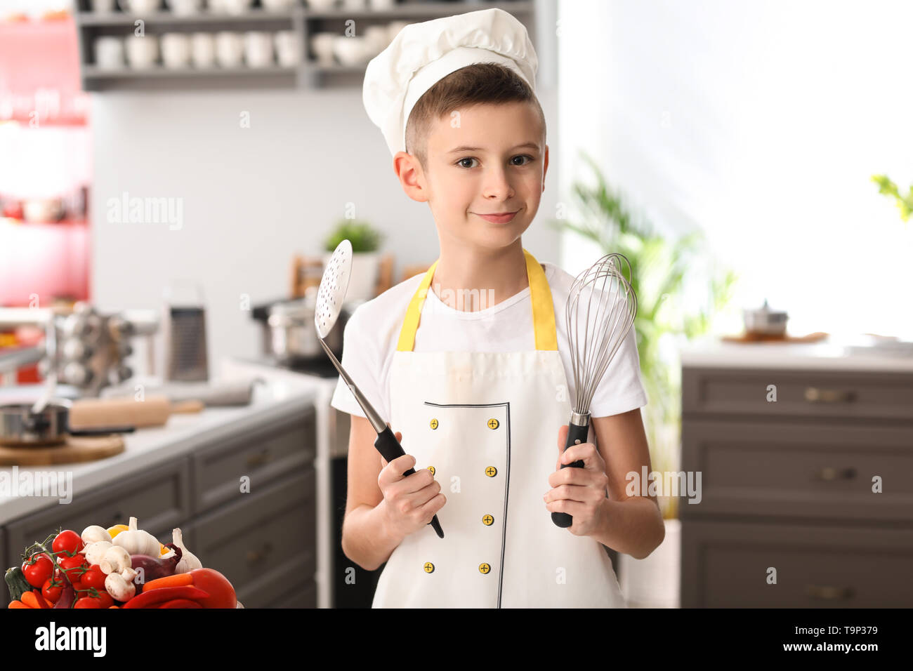 Cute little chef with utensils in kitchen Stock Photo - Alamy