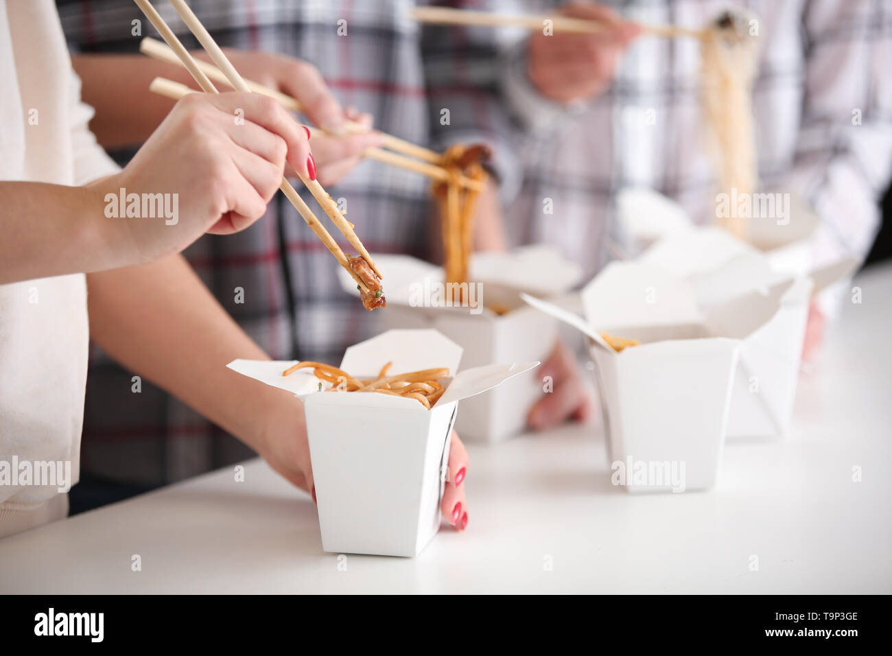 People eating chinese noodles from takeaway boxes, closeup Stock Photo ...