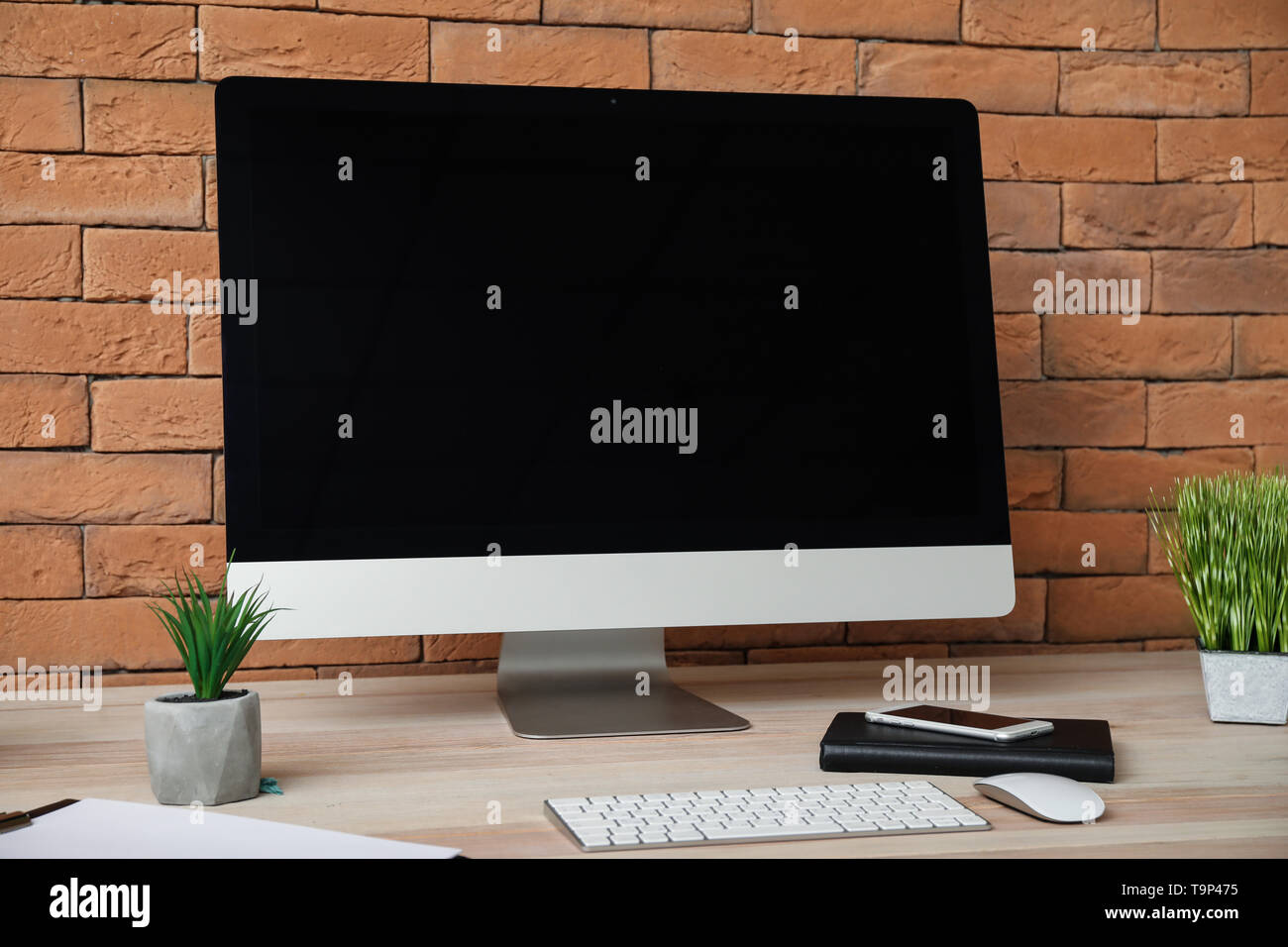 Stylish workplace with modern computer near brick wall Stock Photo - Alamy