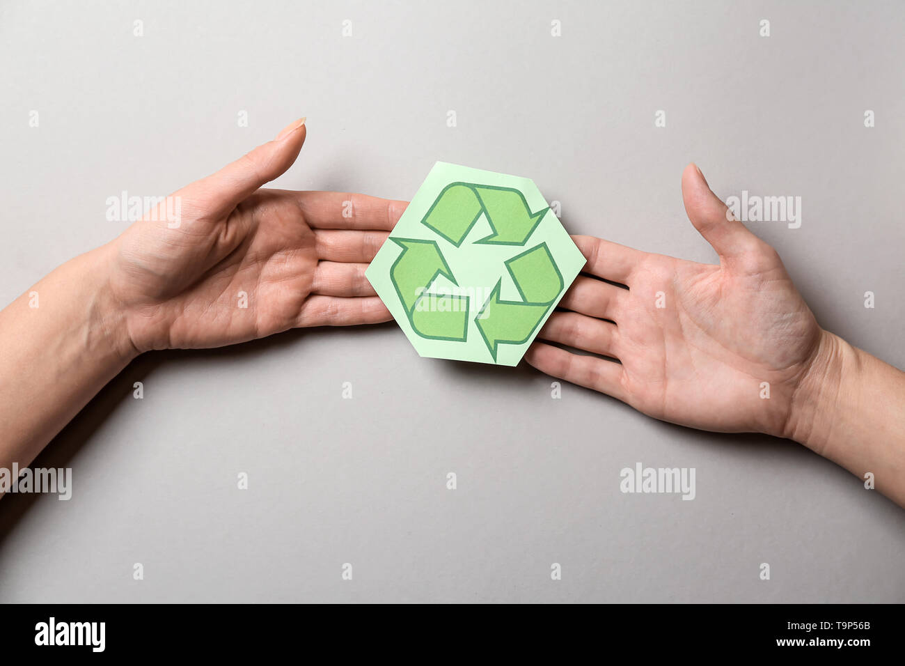 Female hands with recycling symbol on light background Stock Photo - Alamy