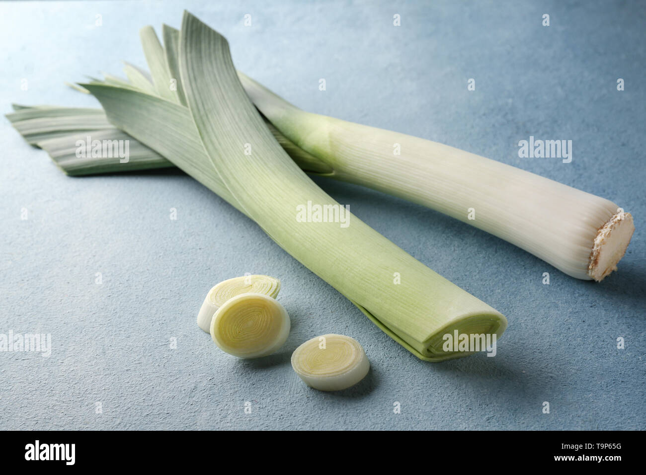 Cut and whole raw leek on grey table Stock Photo - Alamy
