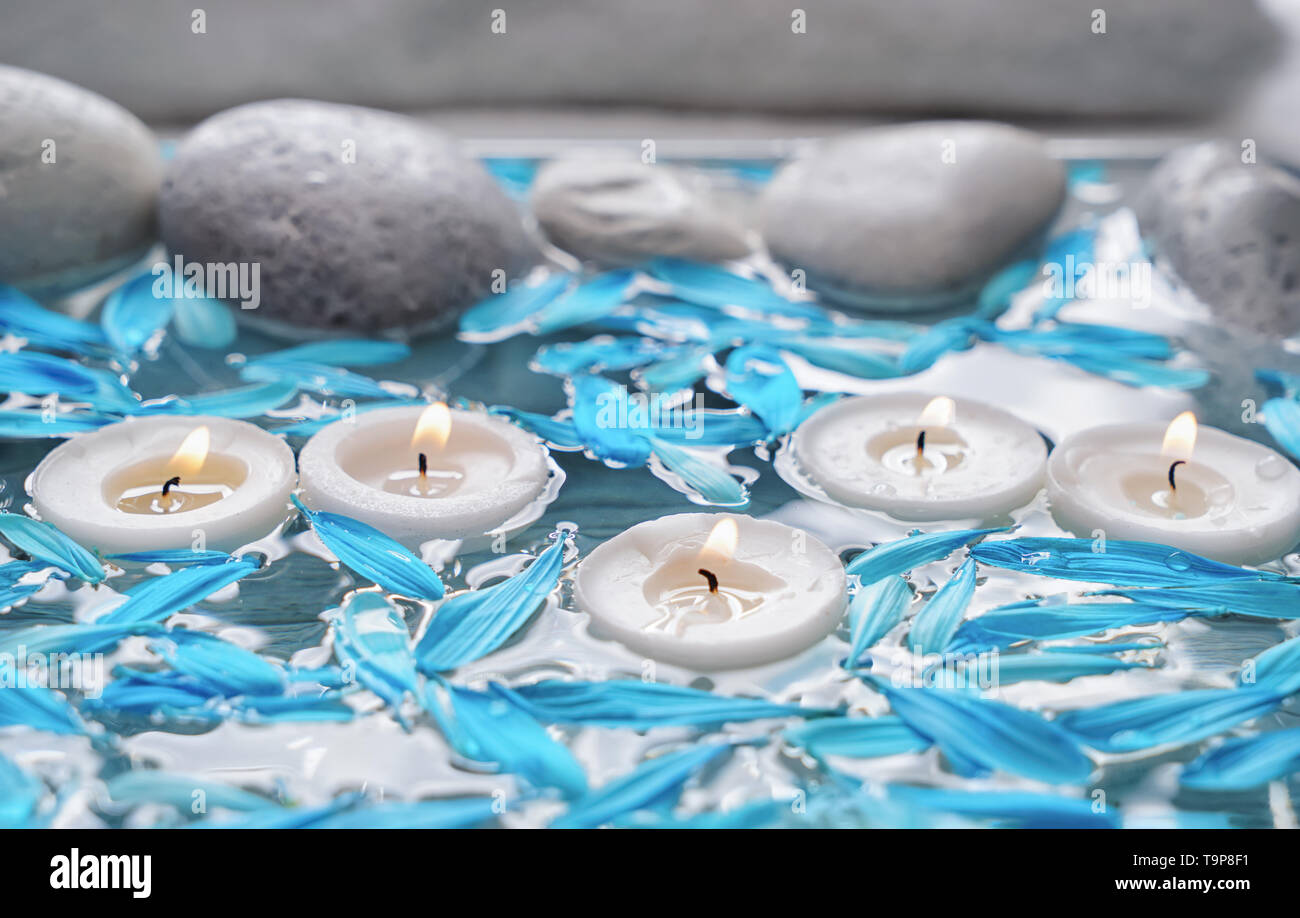 Glass bowl with spa stones and floating flower petals, closeup Stock ...