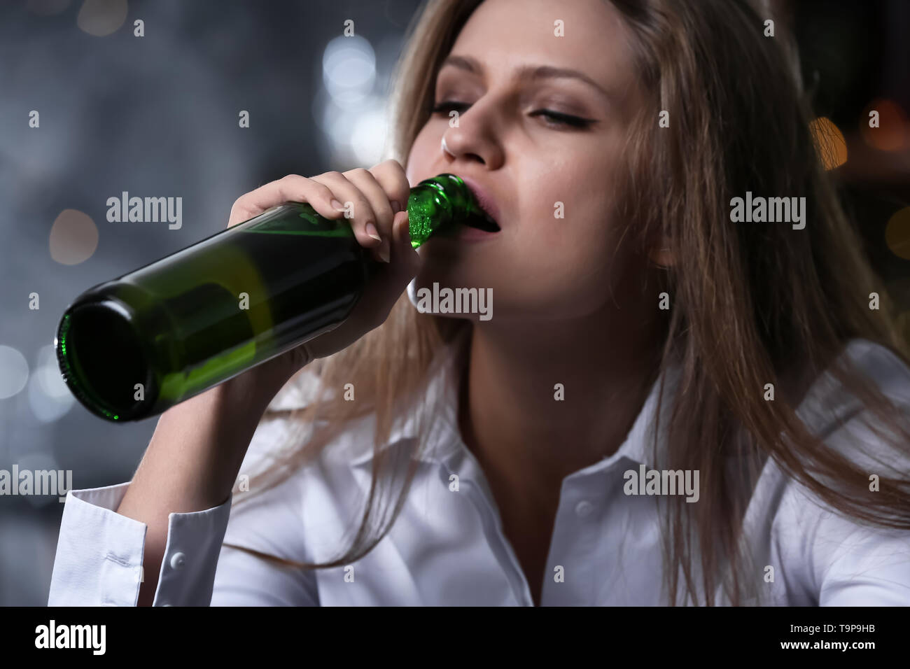 Young woman drinking alcohol in bar Stock Photo - Alamy