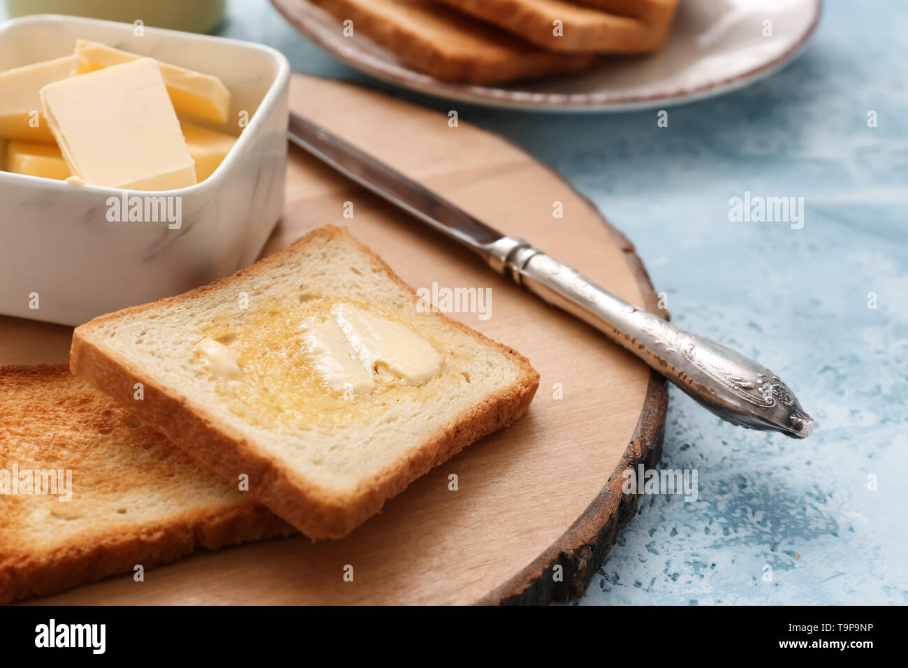 Tasty toasted bread with butter on wooden board Stock Photo - Alamy