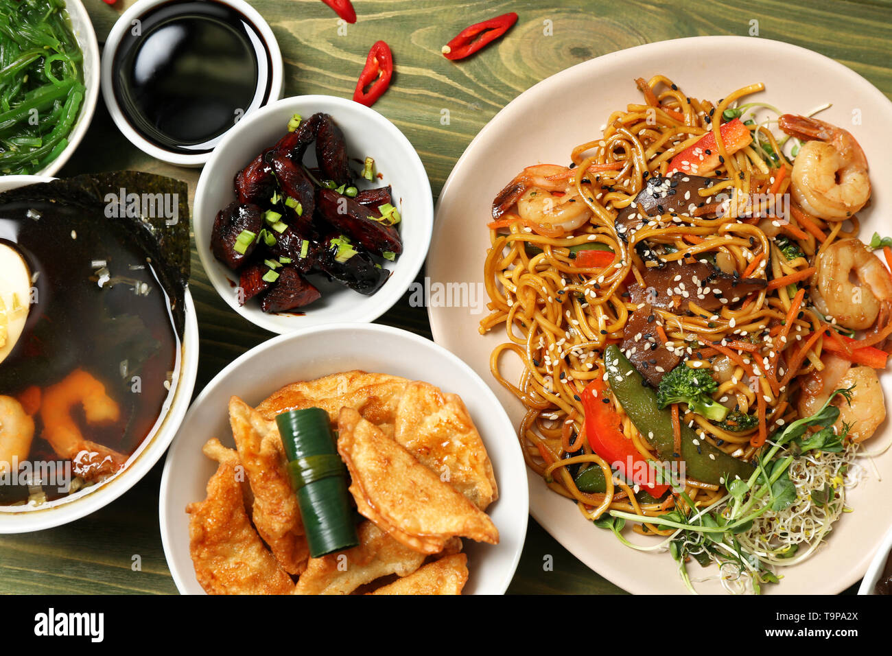 Assortment of Chinese food on wooden table Stock Photo - Alamy