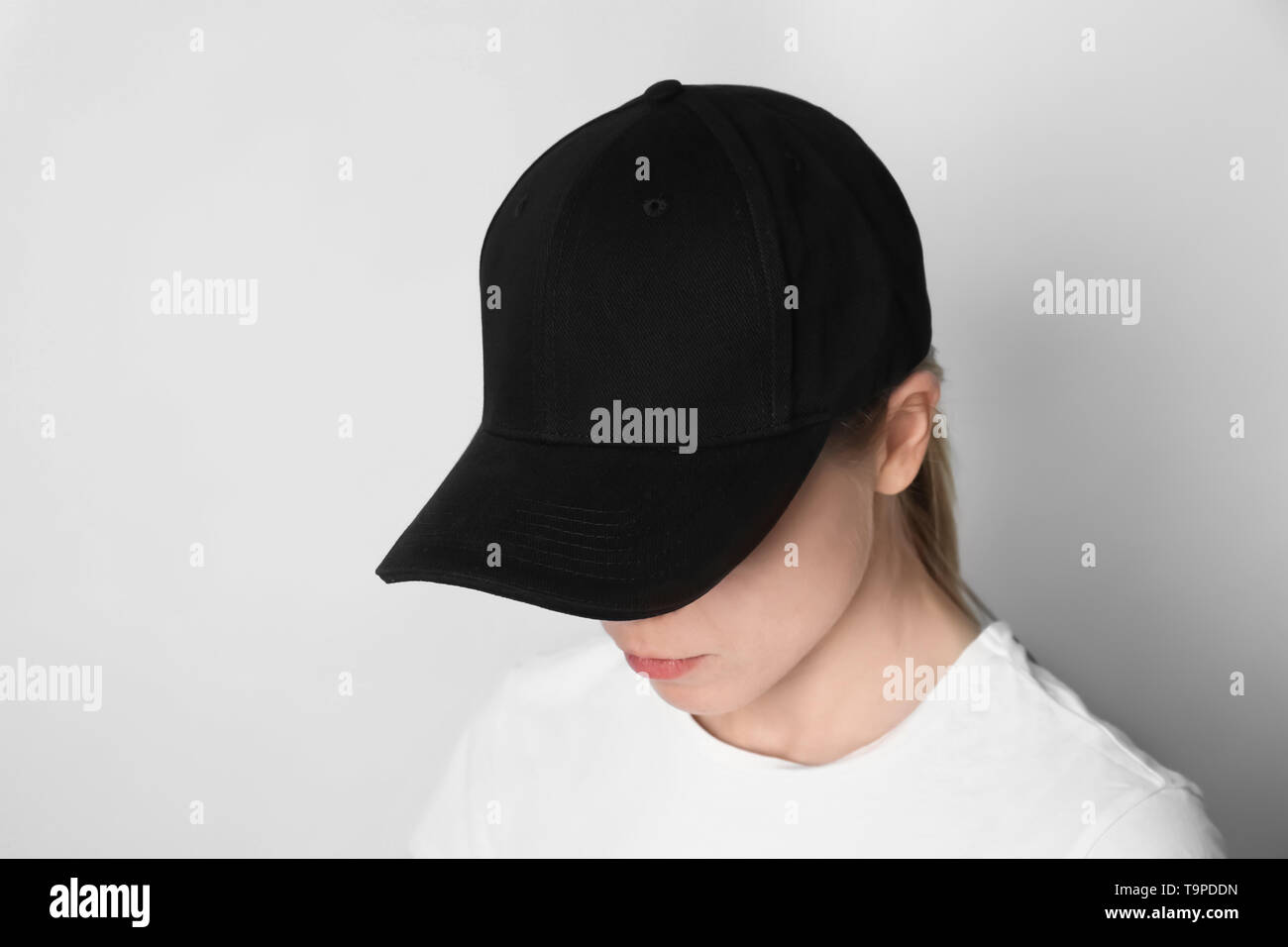 Woman wearing blank cap on light background Stock Photo - Alamy