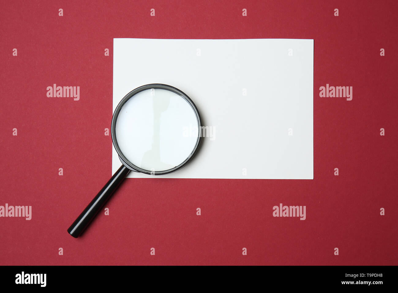 Blank sheet of paper with magnifying glass on color background Stock ...