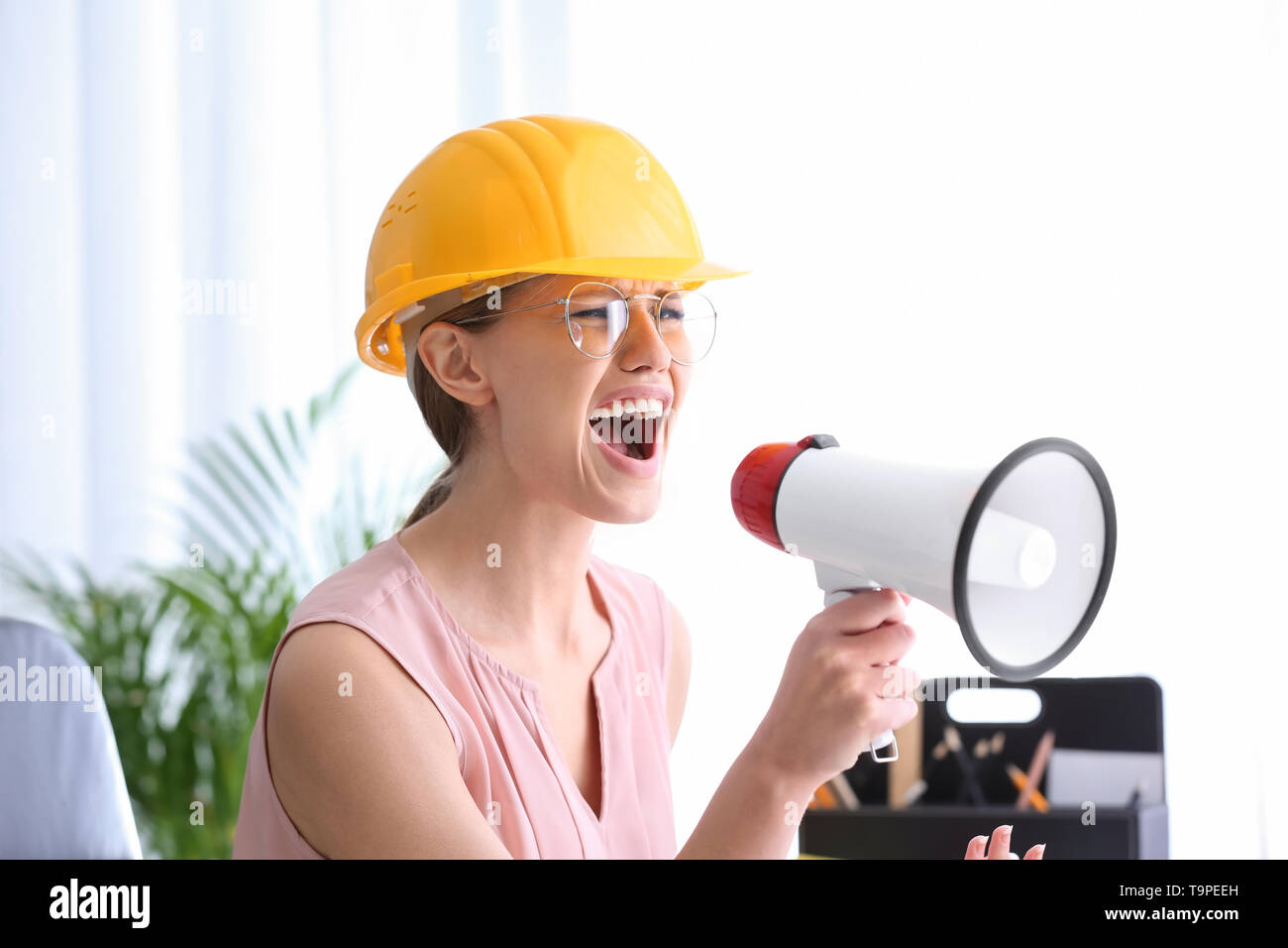 Female engineer using megaphone in office Stock Photo - Alamy