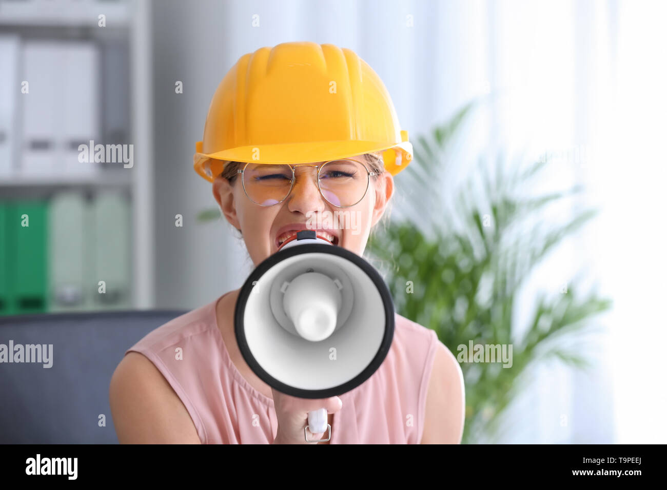 Female engineer using megaphone in office Stock Photo - Alamy