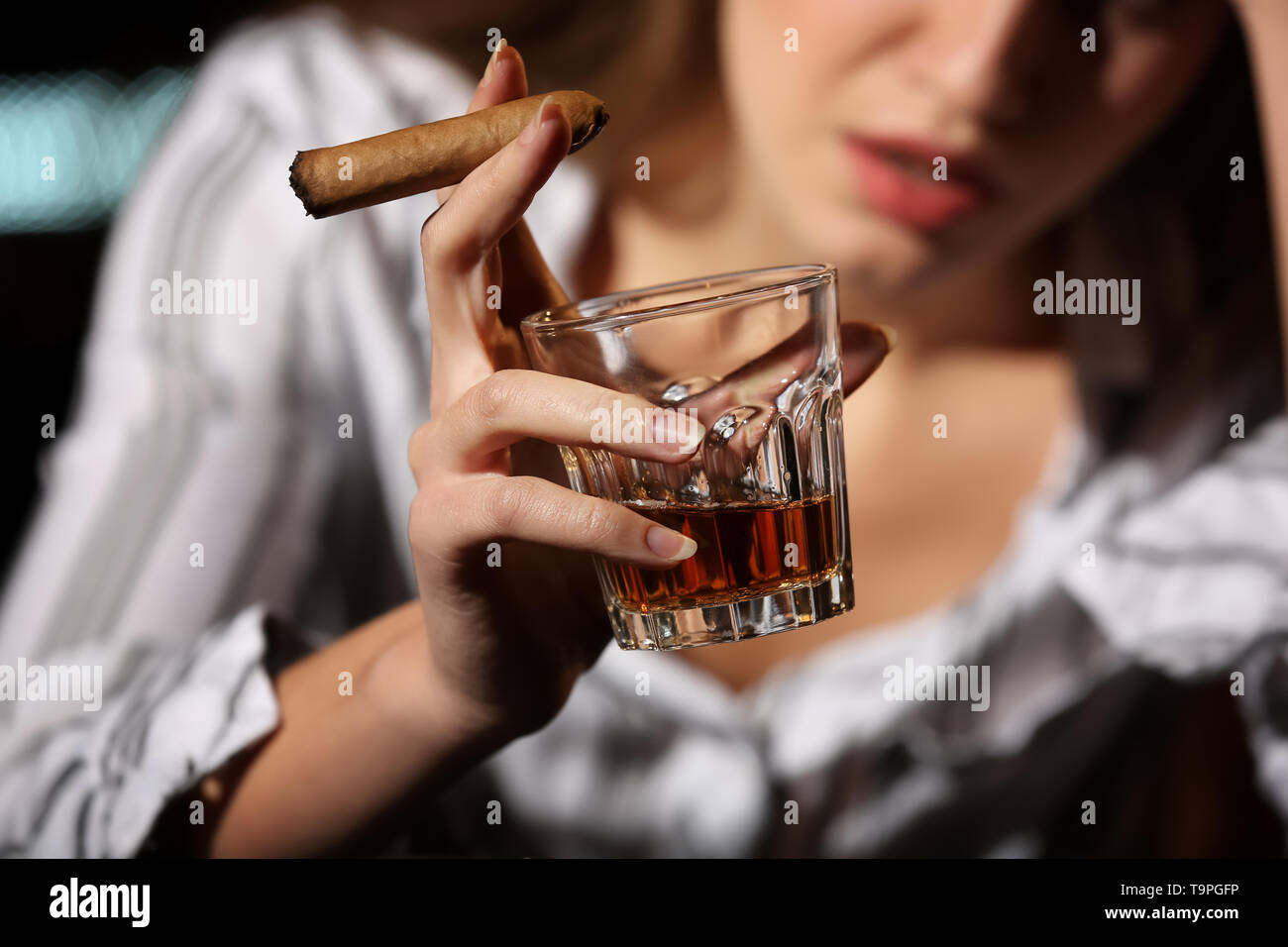 Young woman drinking alcohol and smoking cigar in bar, closeup Stock ...