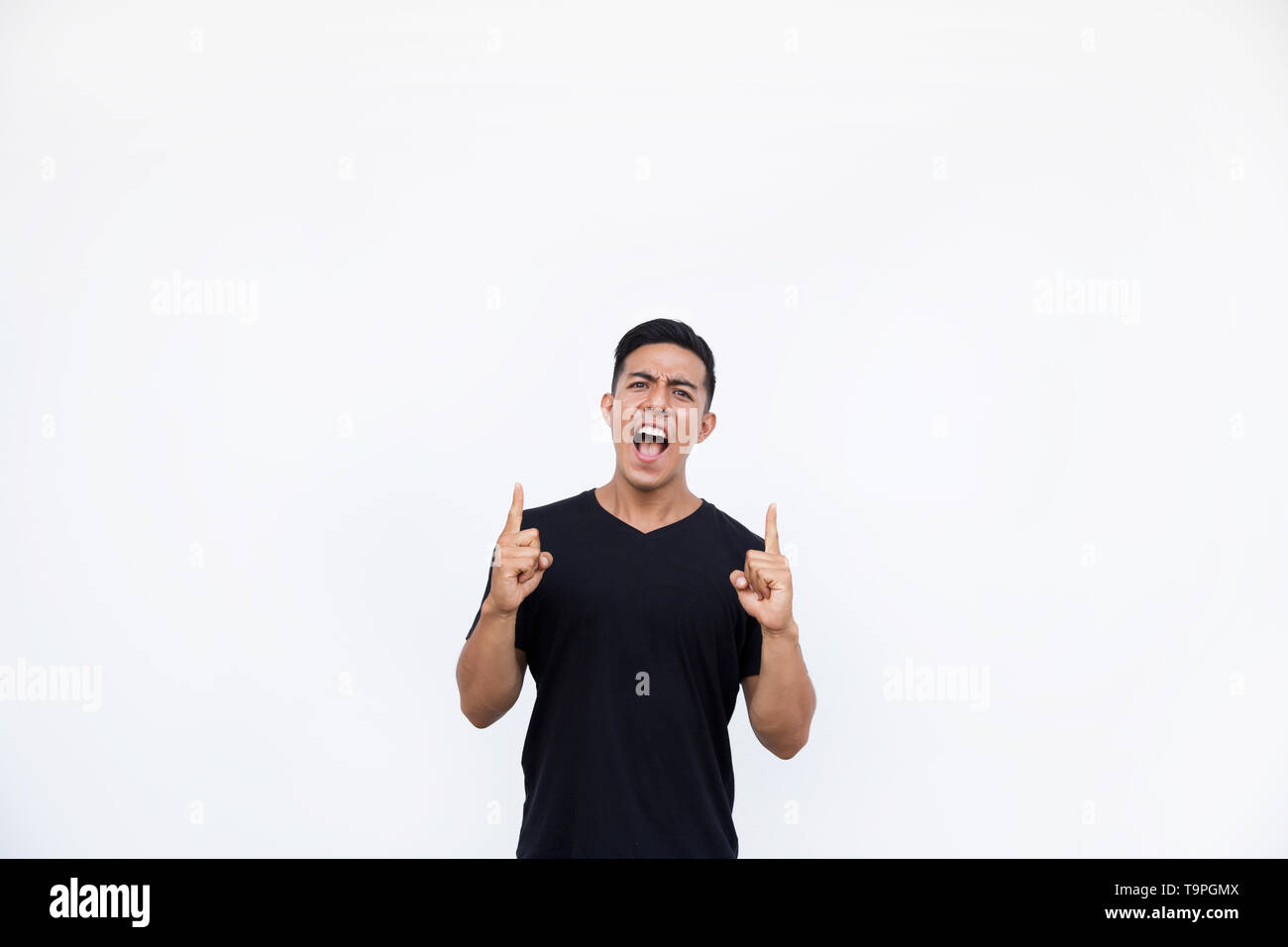 Dynamic image of young male model pointing up and screaming isolated on ...