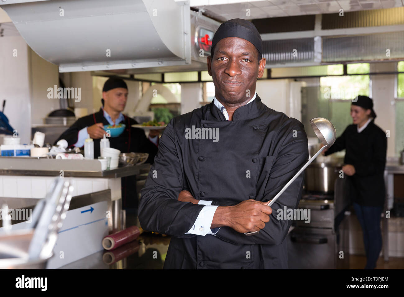 Portrait of confident African American chef in restaurant kitchen with ...